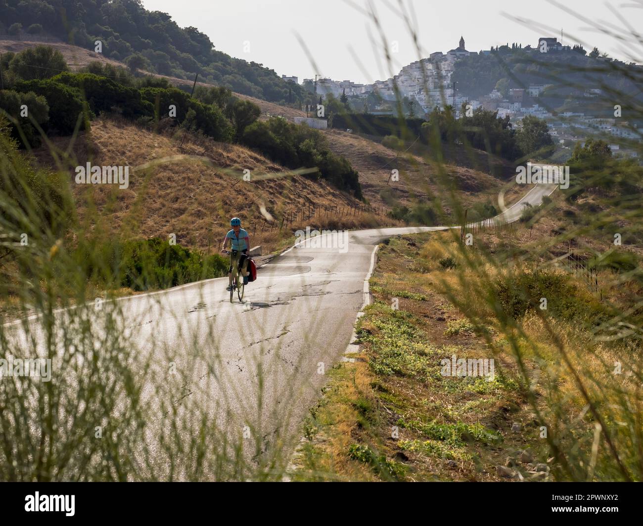 Mature woman riding cycle on village road Stock Photo - Alamy