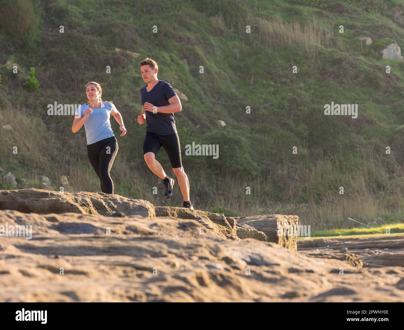 Man and woman jogging on single trail Stock Photo - Alamy