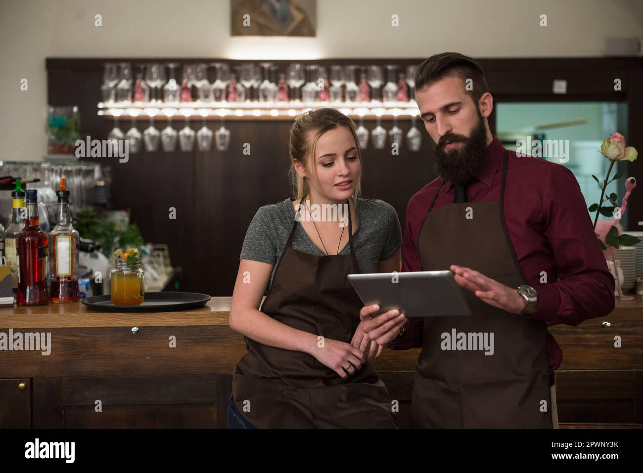 Confident restaurant owners discussing while using digital tablet Stock ...