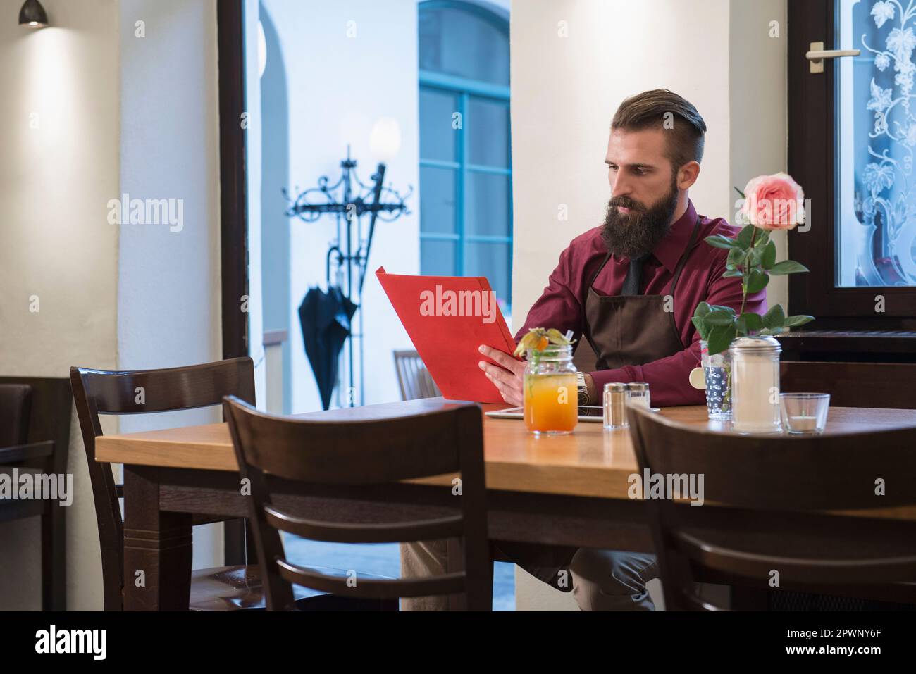 Owner reading menu at restaurant Stock Photo - Alamy