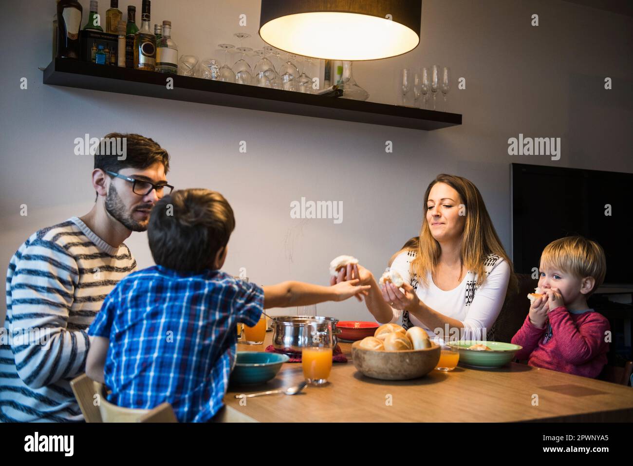Mother is offering bread to her son while family watches, Munich ...