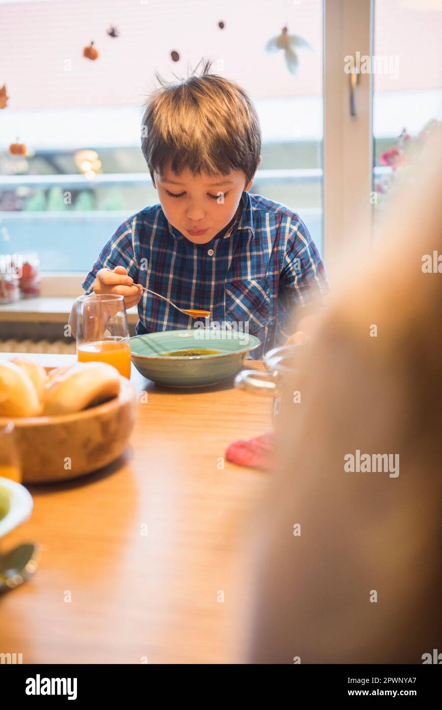 Boy blowing the hot soup, Munich, Germany Stock Photo - Alamy
