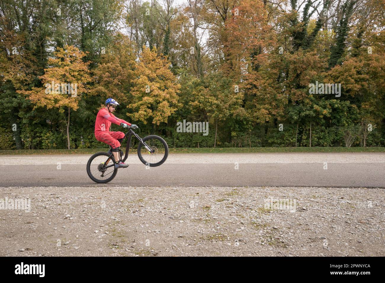 Man doing wheelie on mountain bike Stock Photo - Alamy