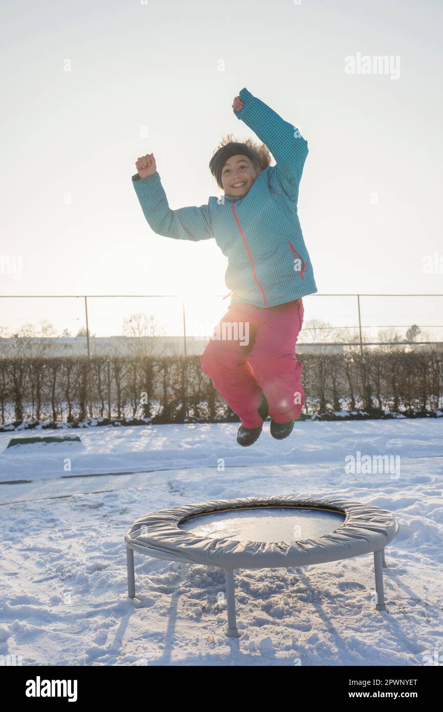 Girl jumping on trampoline Stock Photo - Alamy