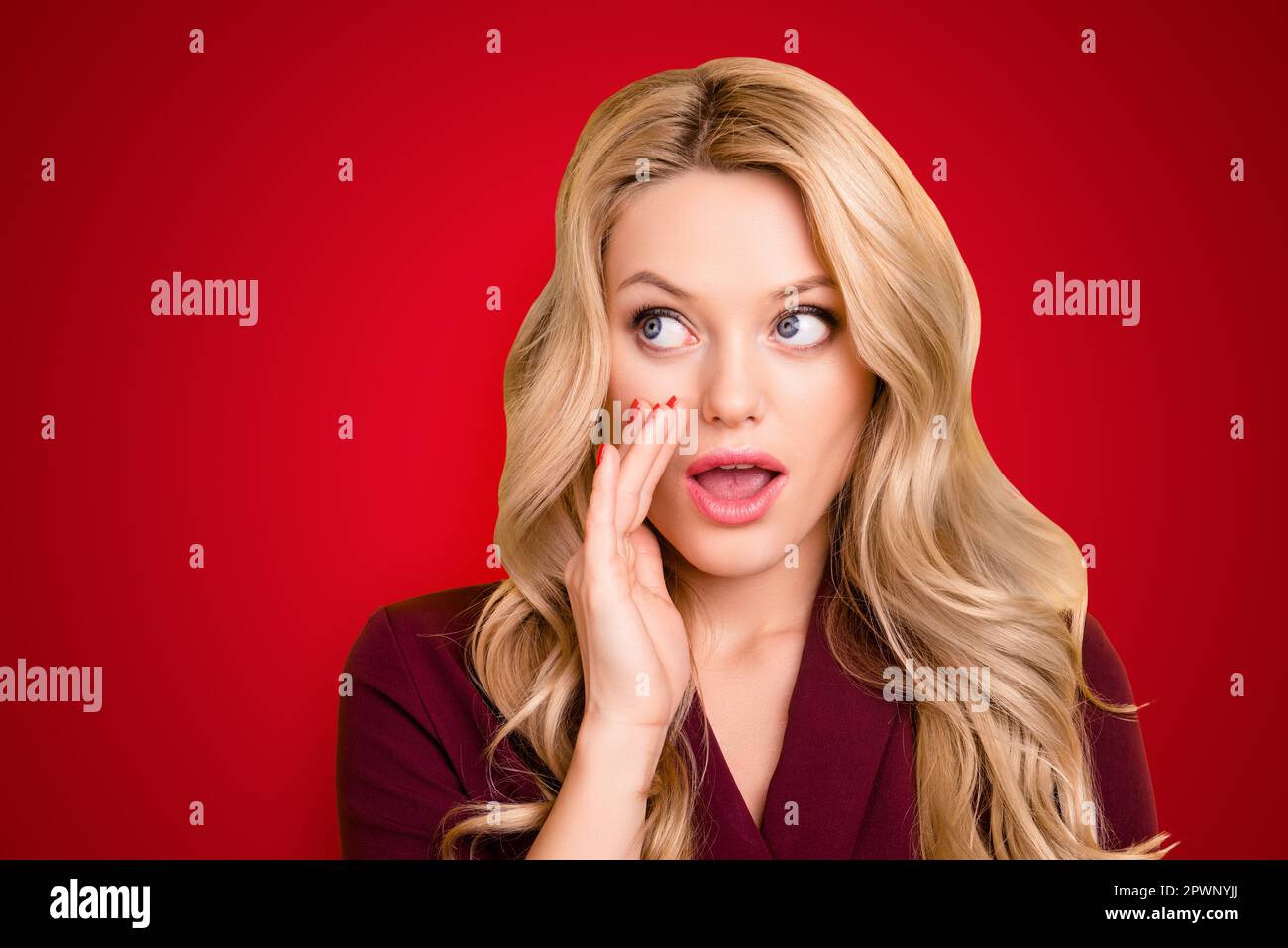 Portrait of concentrated big-eyed woman in classic outfit hiding mouth with palm whispering ...