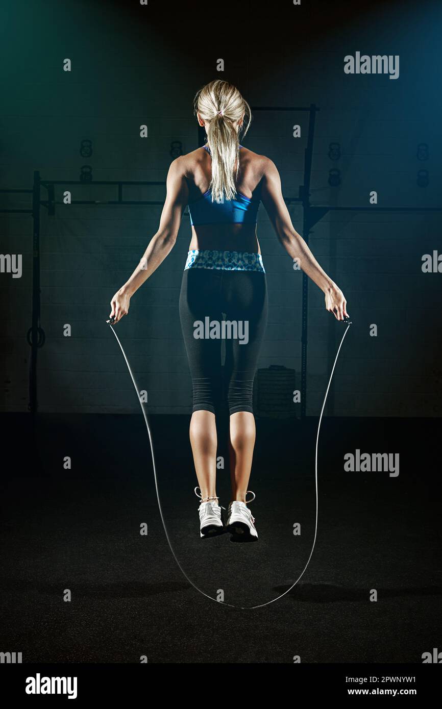 Lifes short, go rope. a young woman jumping rope in a gym Stock Photo ...