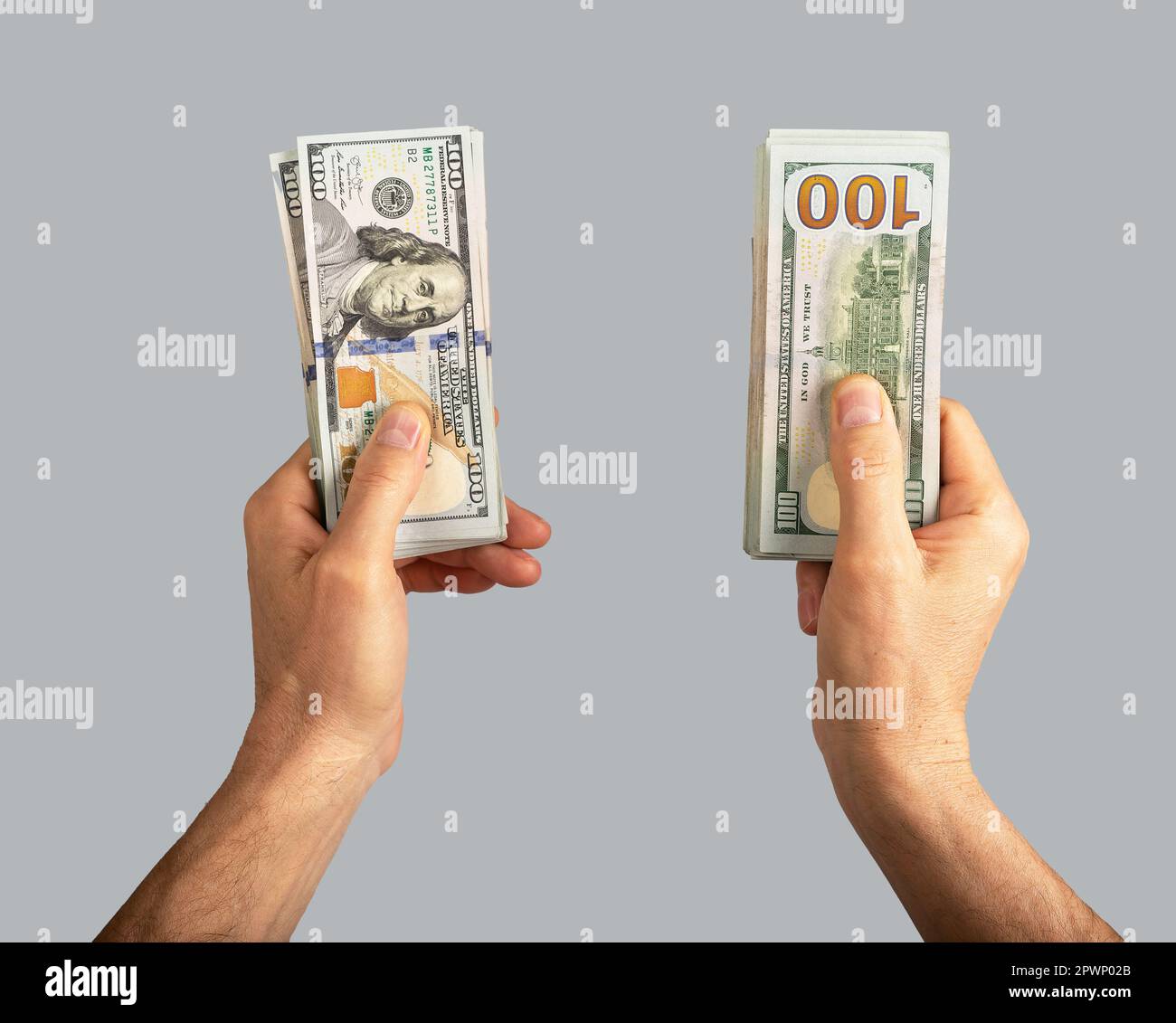 Hand holding two banknotes stacks, dollar money concept Stock Photo - Alamy