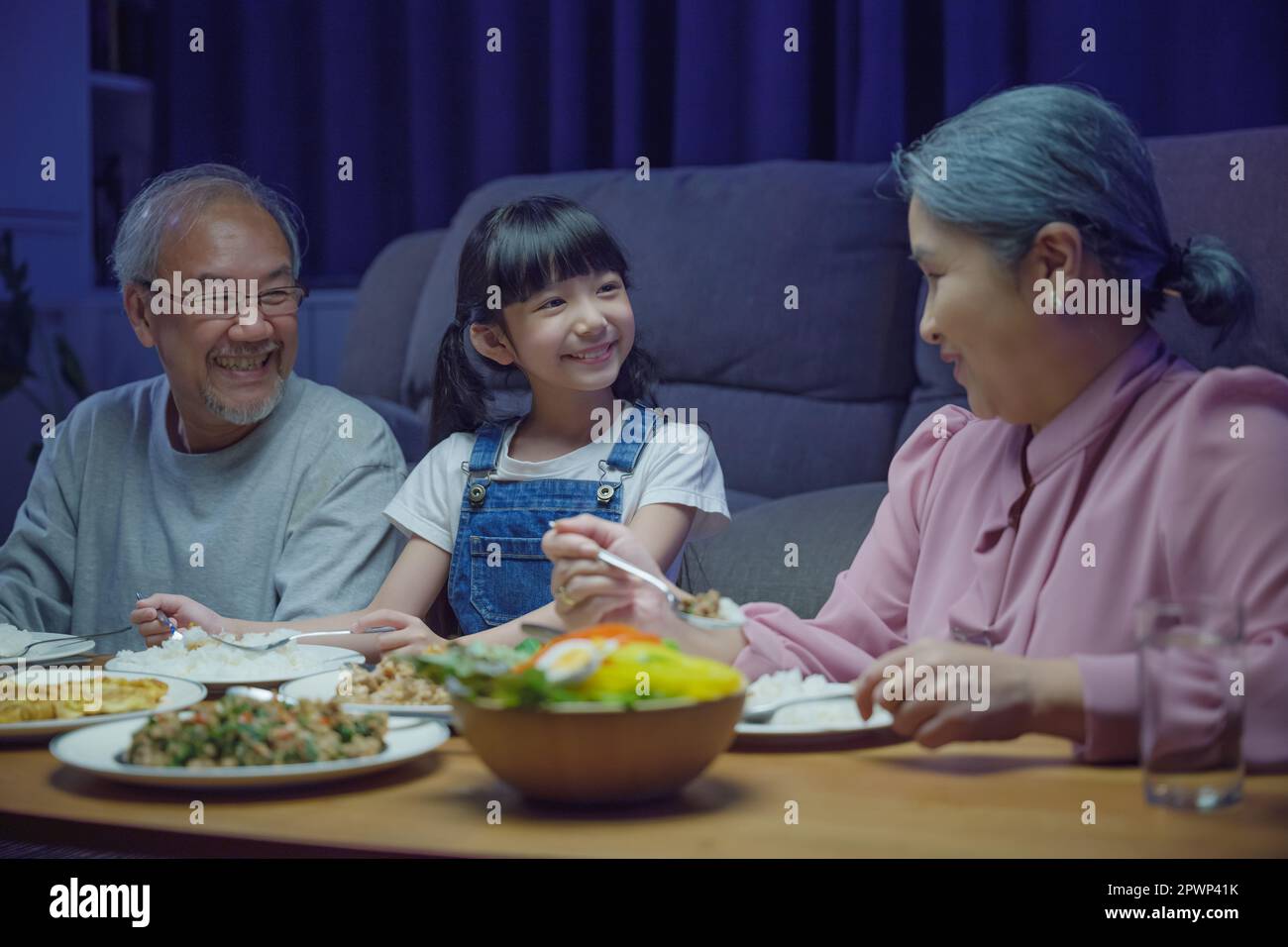 Happy Asian senior parent and child eating dinner food together in ...