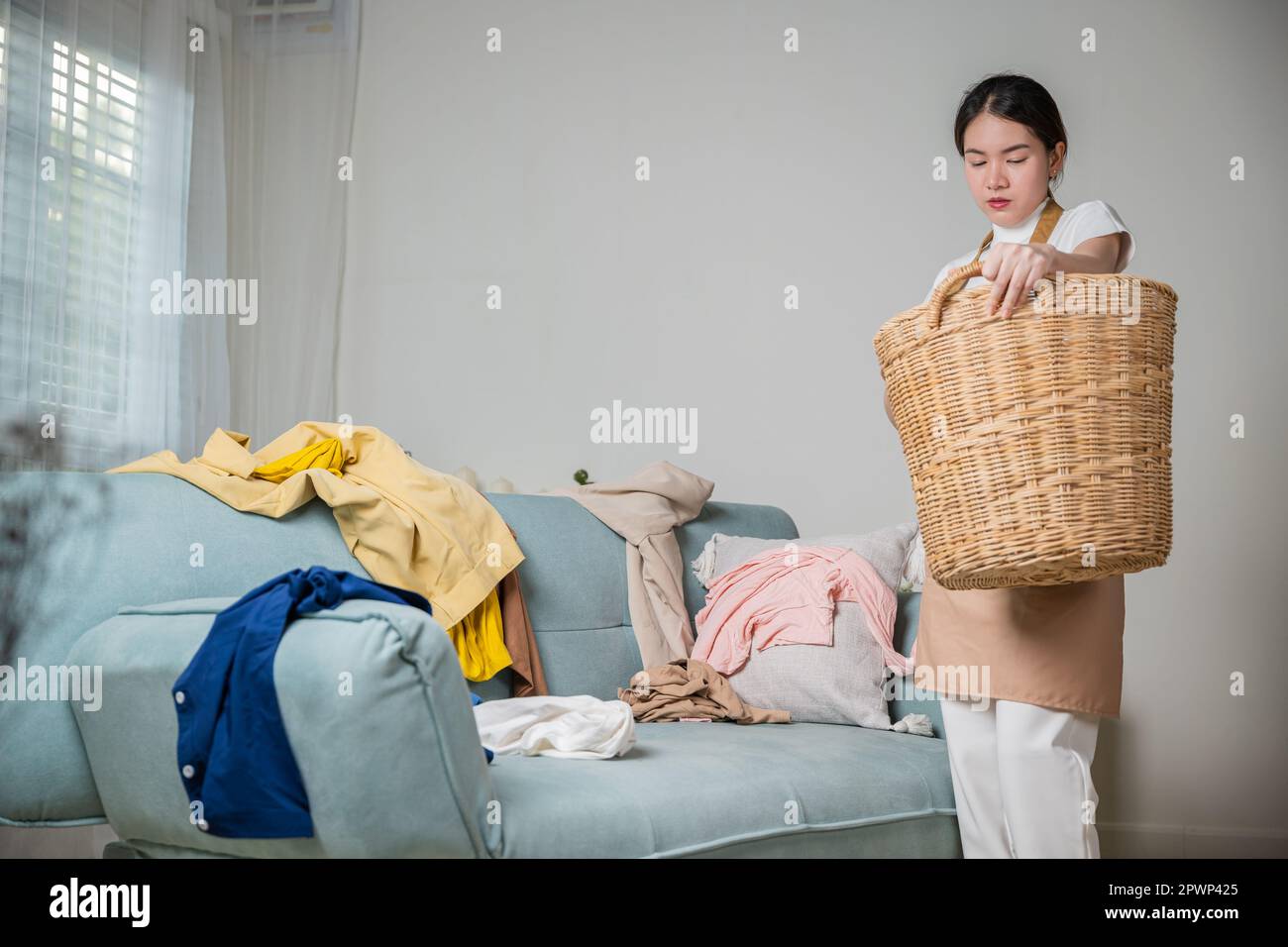 Beautiful housekeeper doing housework holds wooden basket of clean ...