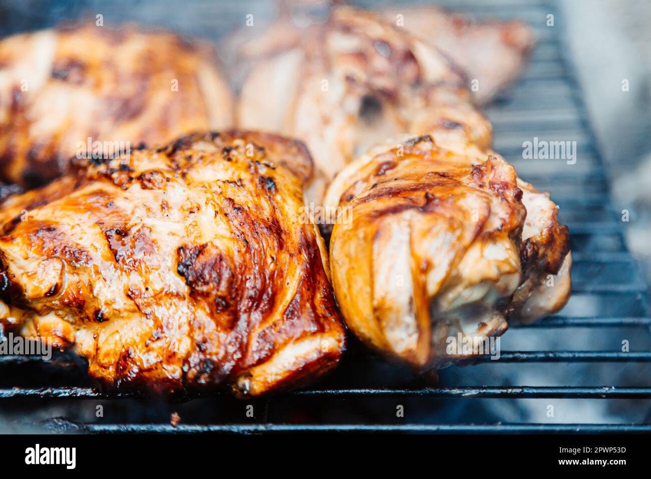 Chicken thighs Barbecue on The Hot Grill Close-up. Fire flames in the ...