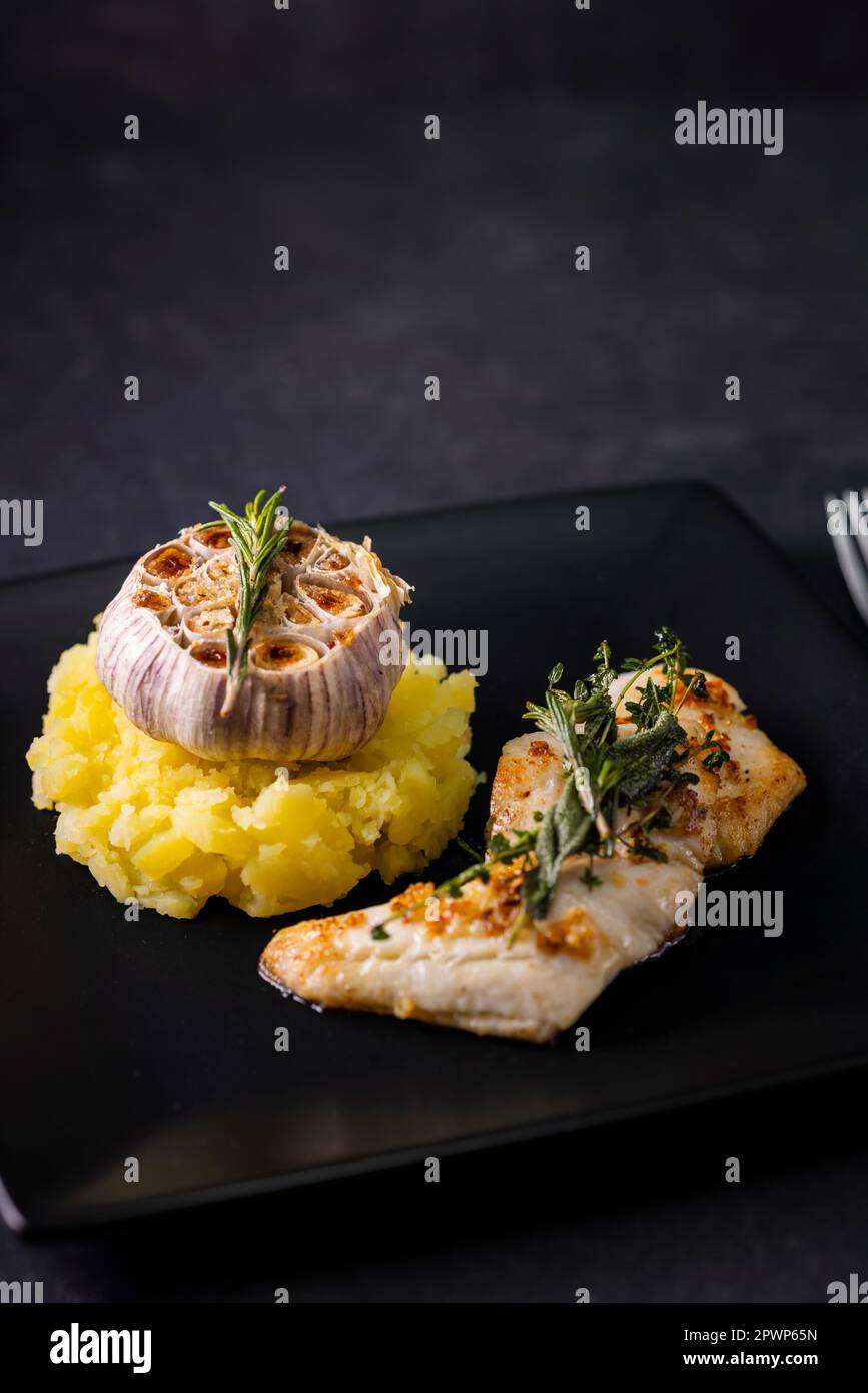 cod fillet with couscous and roasted garlic Stock Photo - Alamy