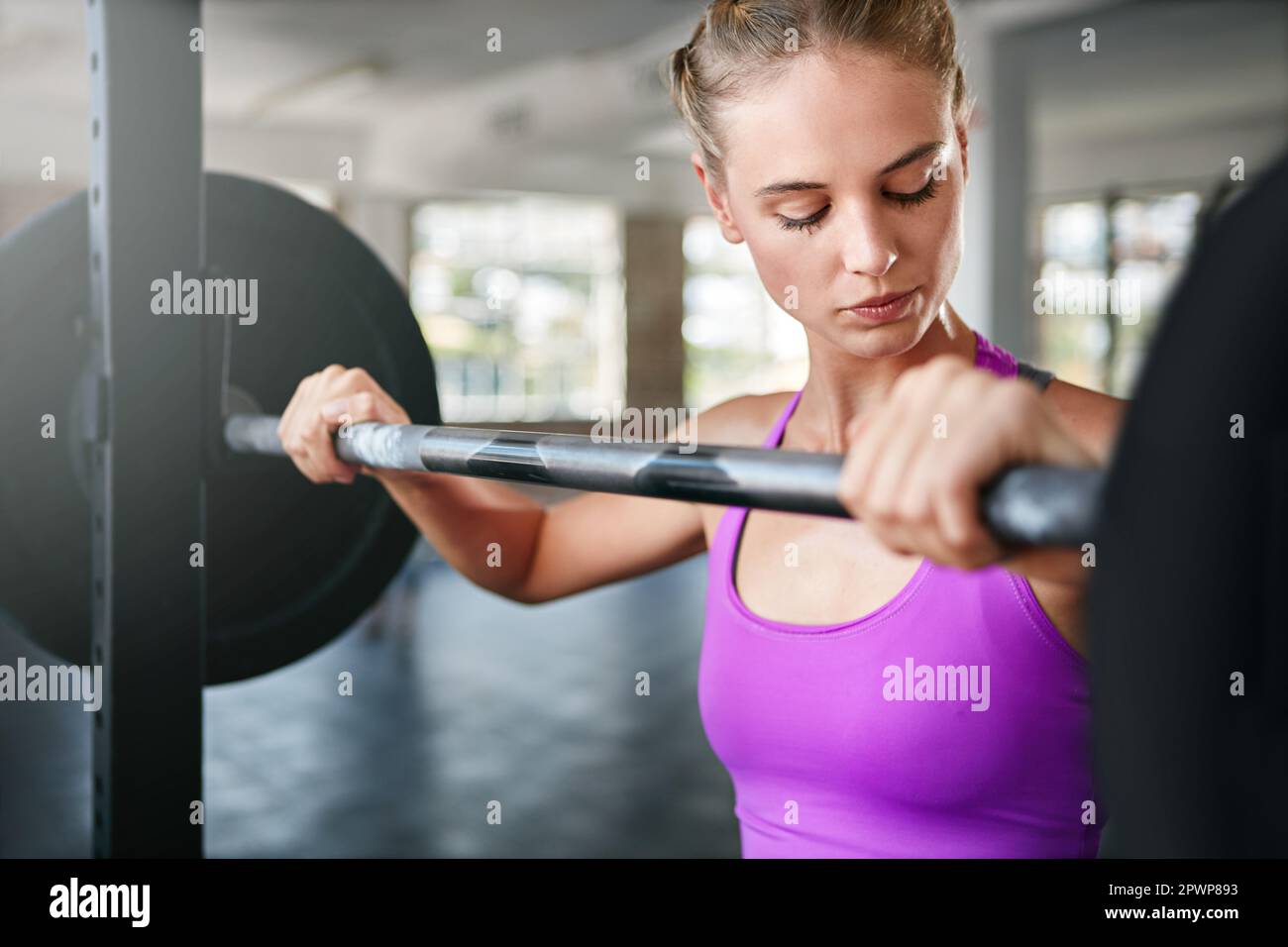 Strong is the new beautiful. a young woman working out with weights at ...