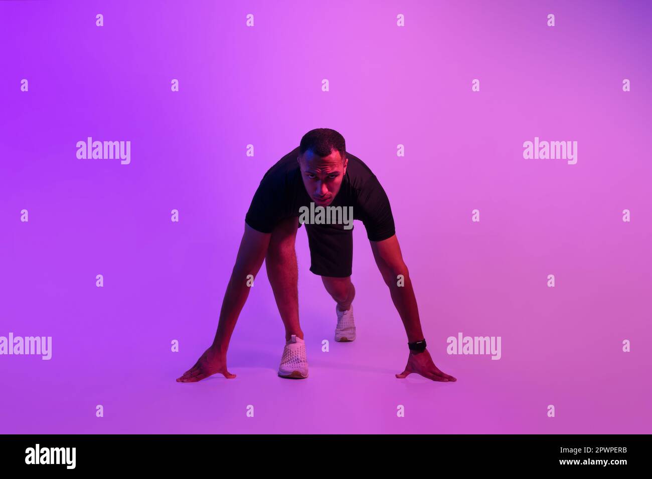 African Sportsman Posing In Crouch Start Position On Purple Background ...