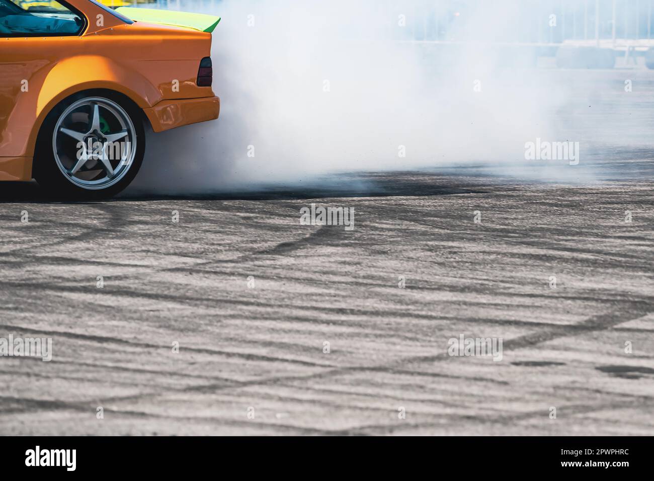 closeup side view of yellow sport car drifting on gray speed tarmac ...