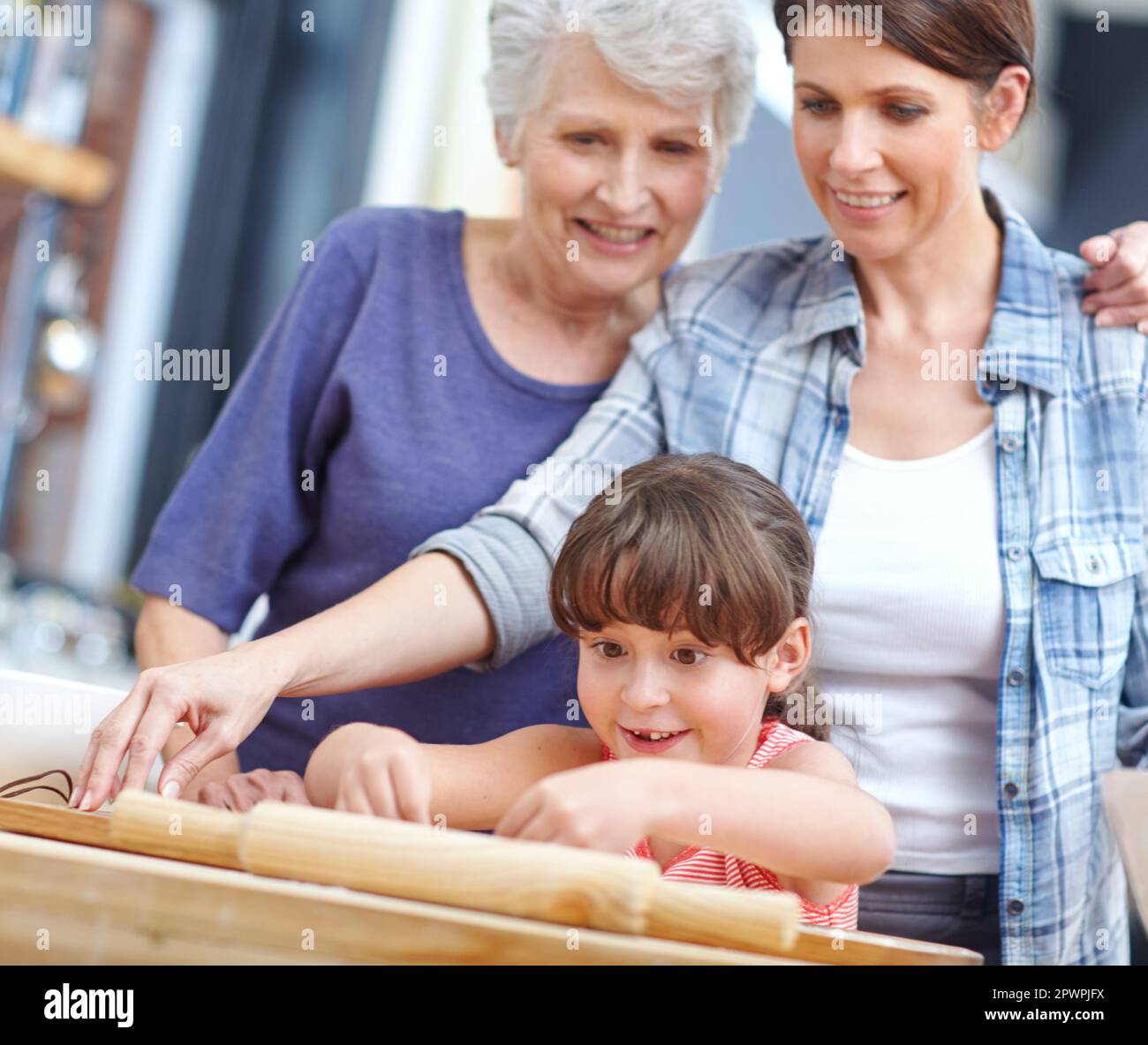 Shes doing it perfectly. a three generational family baking together ...