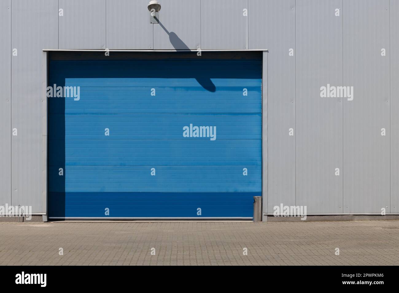 Blue roller shutter entrance to industrial loading area Stock Photo - Alamy