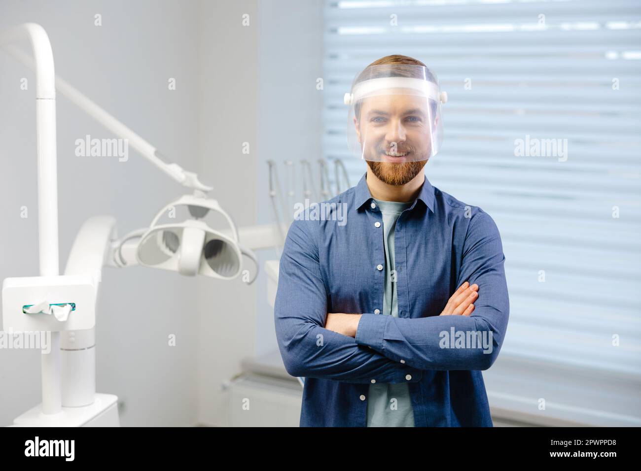 Medical safety. Portrait of young dentist doctor in face shield posing ...