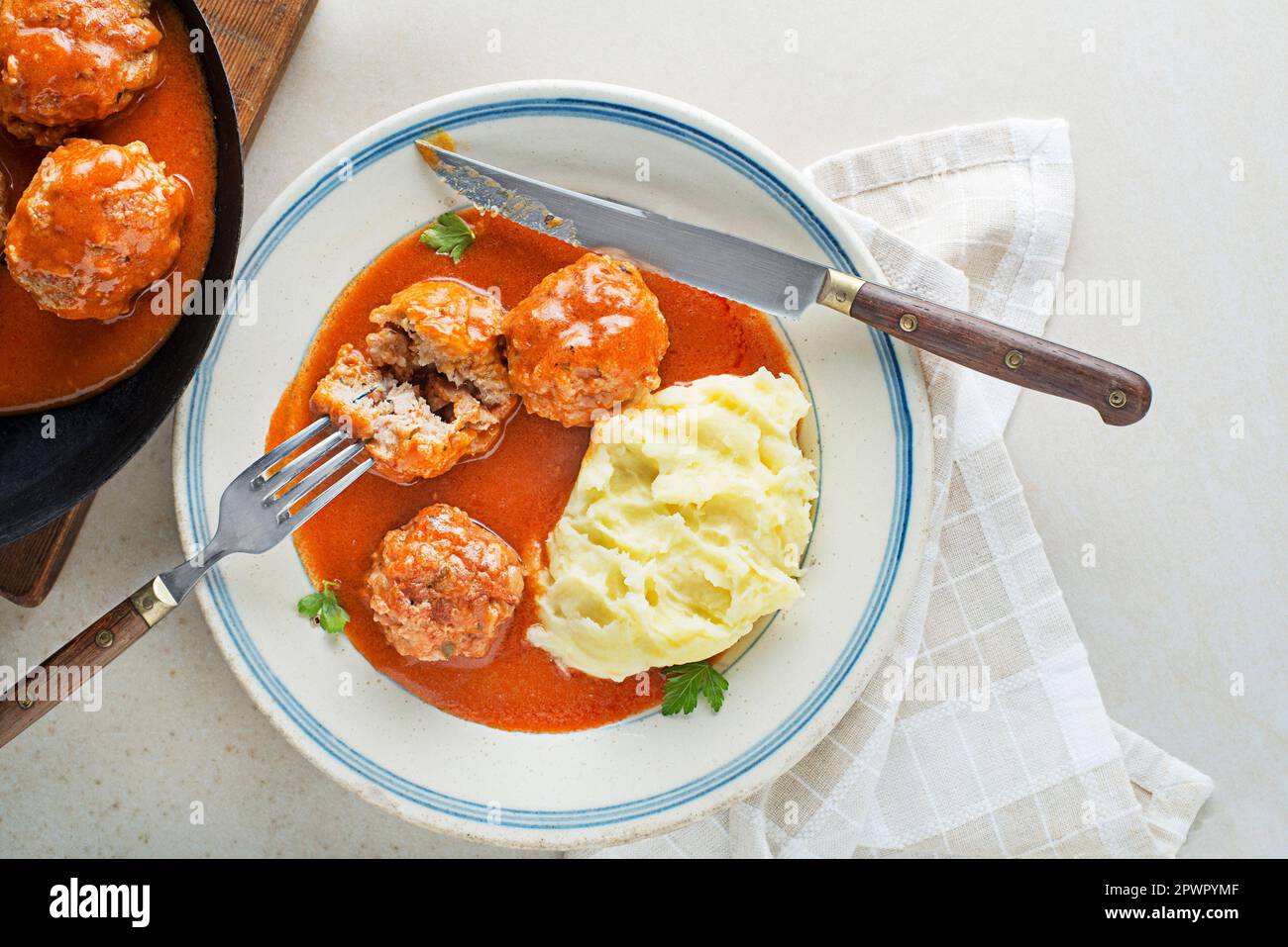 Fried meatballs braised in tomato sauce served with mashed potatoes on ...