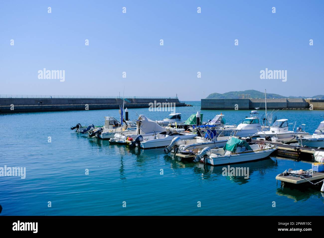 Boats in a Jetty by the sea, with island in the background Stock Photo ...