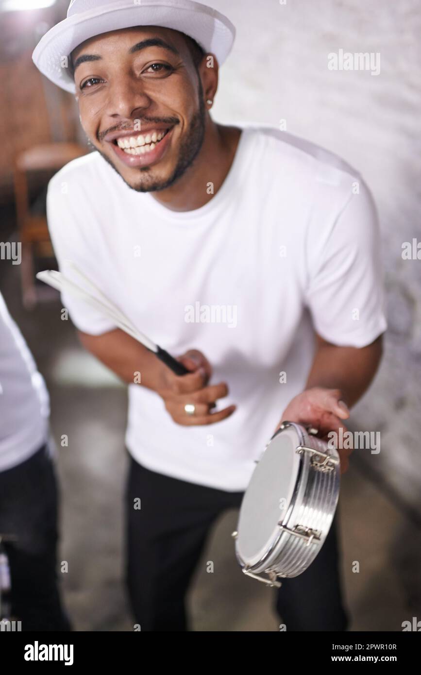 Feeling the rhythm in the drums. Portrait of a young ethnic drummer ...
