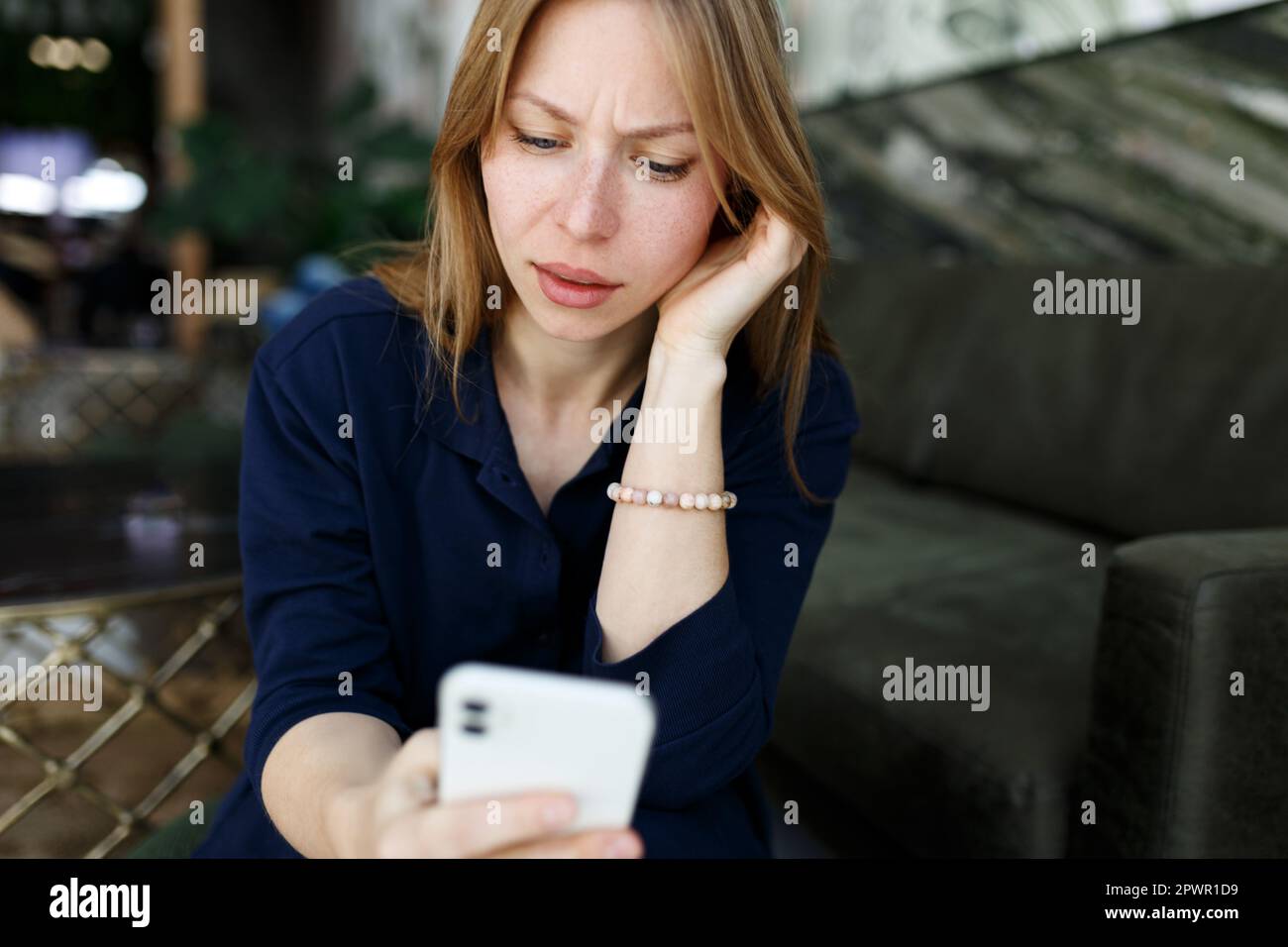 Young woman sad, reading bad news email, break up message from ex ...