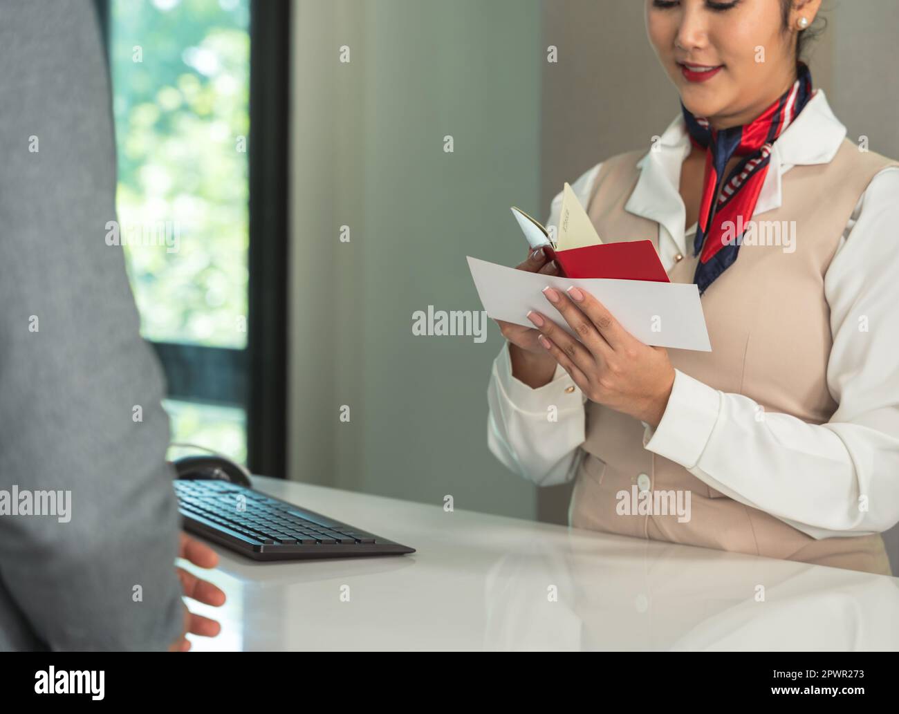 Female flight attendant checking passport and boarding pass at airport ...