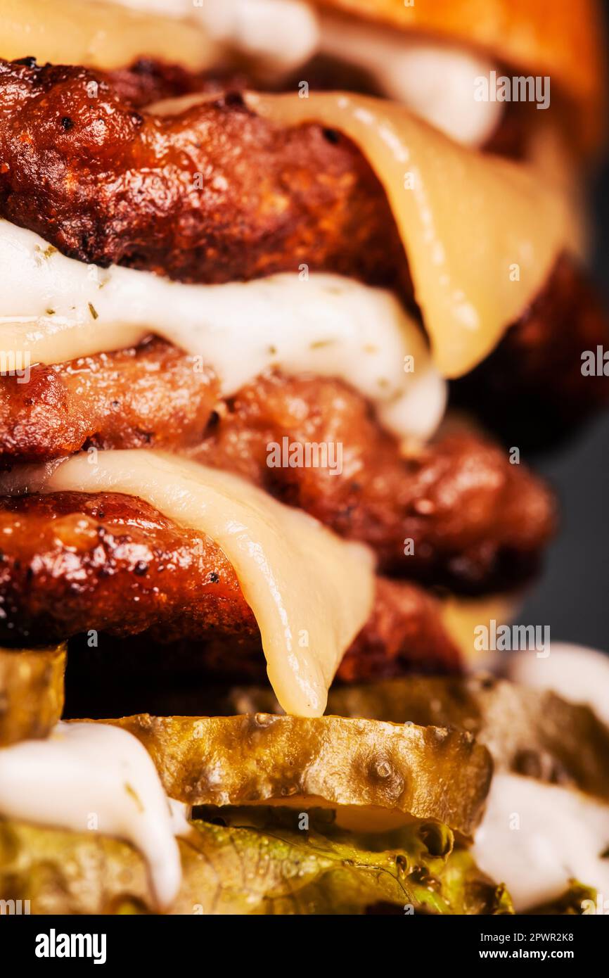 Abstract junk food. Quadruple burger with cheese cucumber and lettuce ...