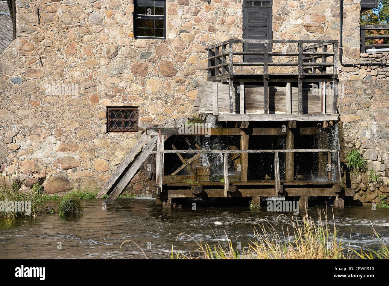 Water mill wheel rotates under a stream of water Stock Photo - Alamy