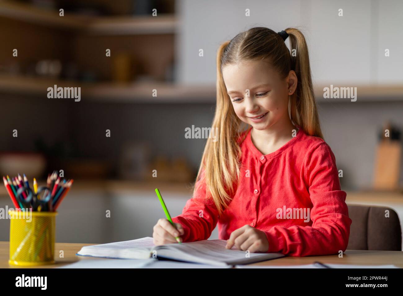 Portrait Of Cute Little Girl Doing School Homework With Book At Home ...