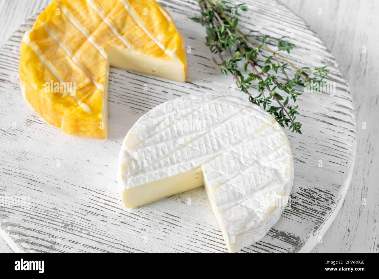 Two camembert cheese wheels on the cutting board Stock Photo - Alamy