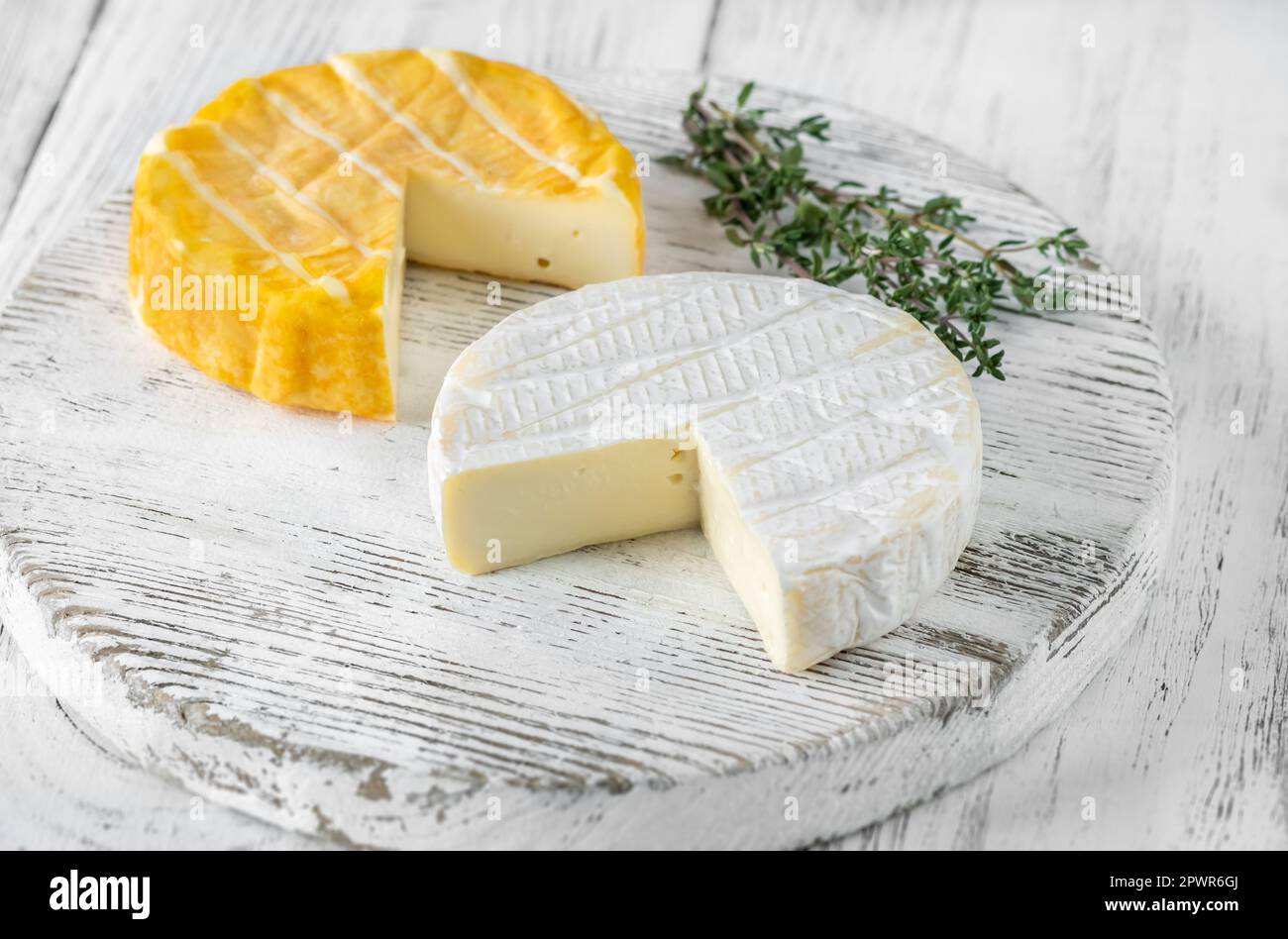 Two camembert cheese wheels on the cutting board Stock Photo - Alamy