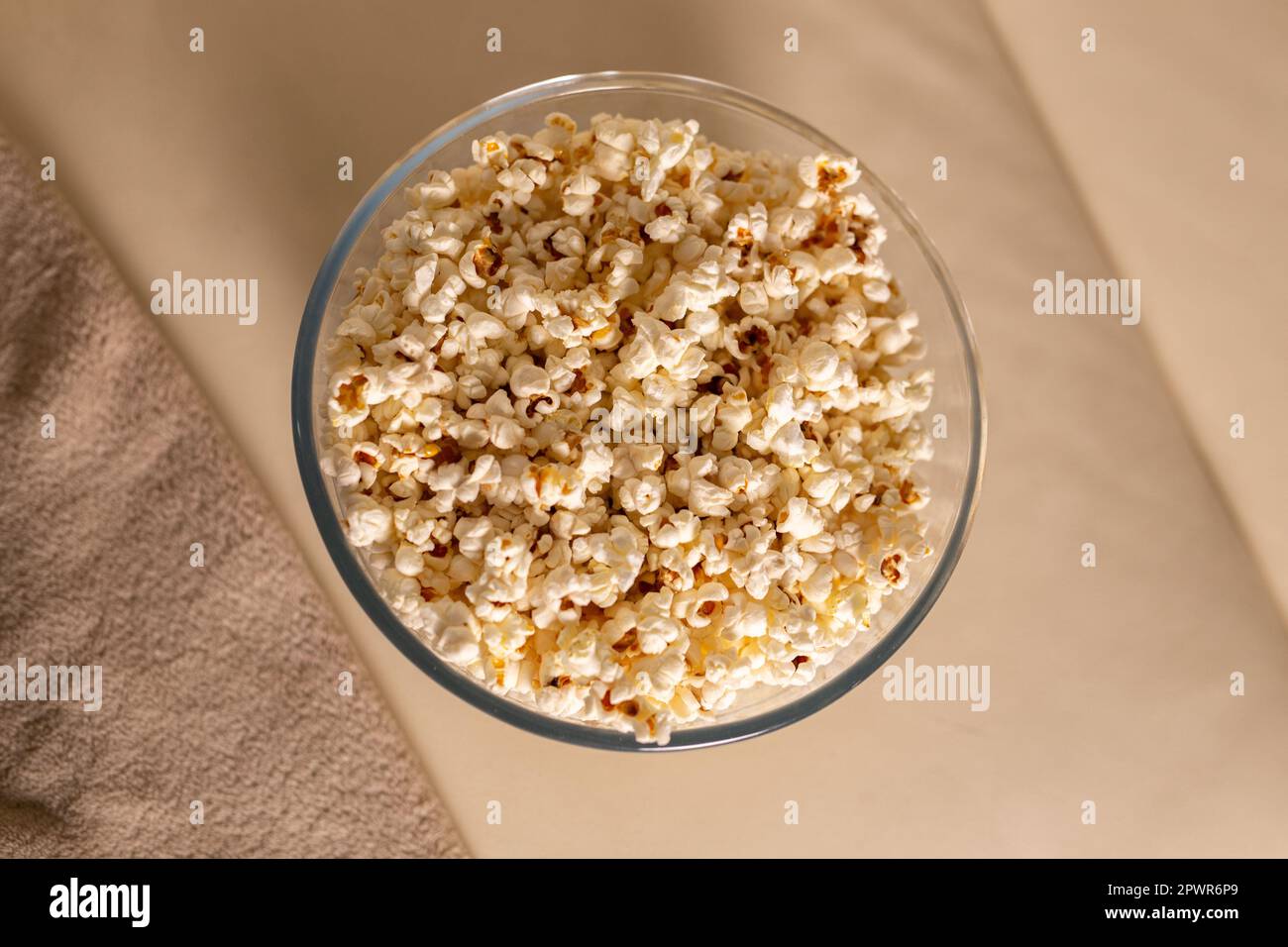 Bowl of popcorn for watching a film on a beige couch. Snacks and ...