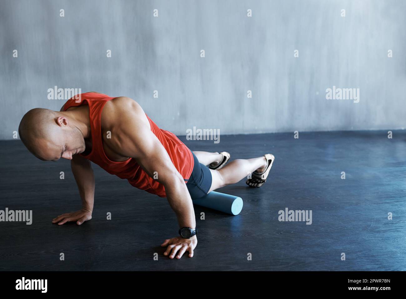 Rolling his way to fitness. A young man doing push-ups with a foam ...