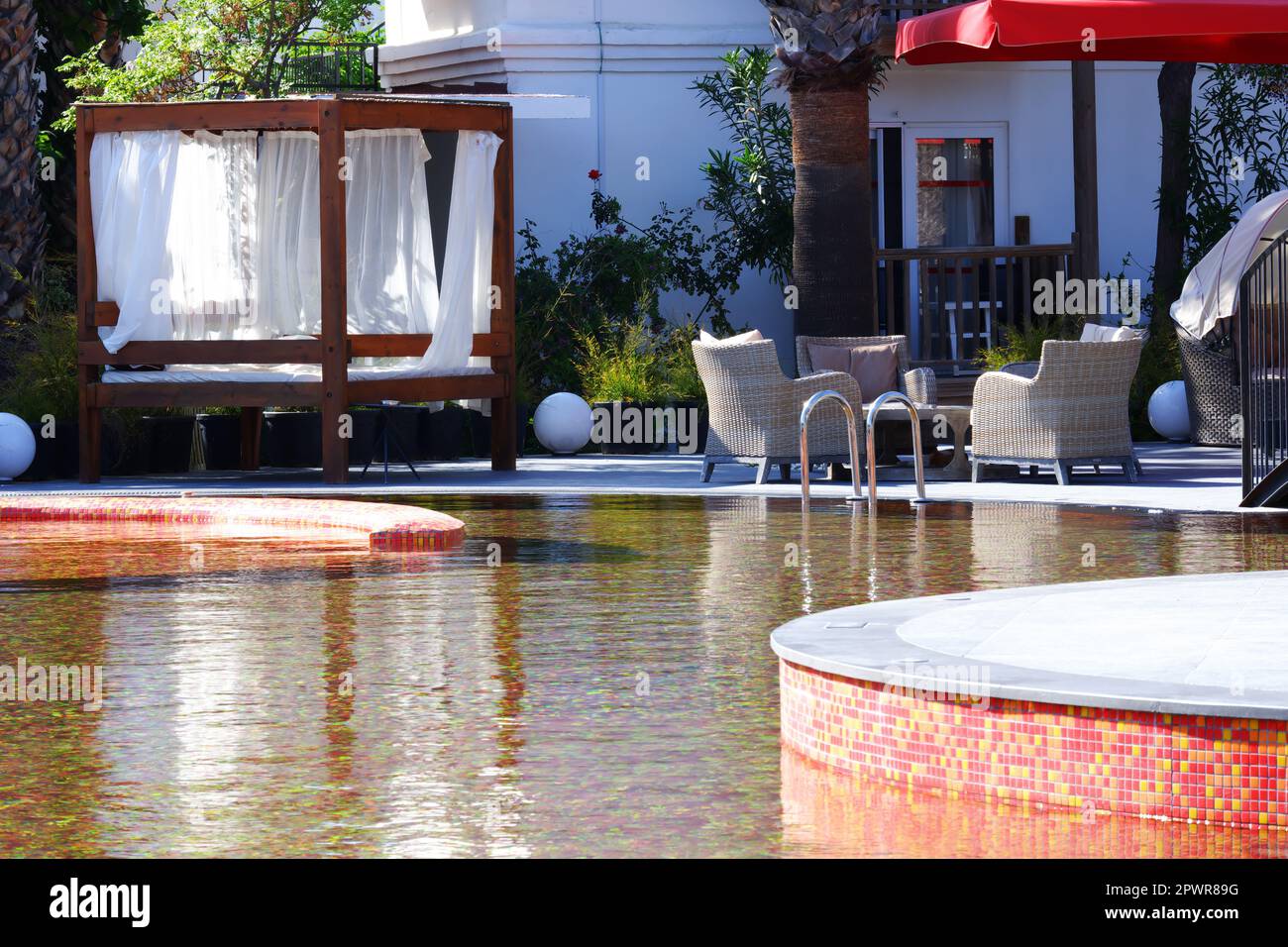 Empty hotel pool with chairs and tables poolside Stock Photo - Alamy
