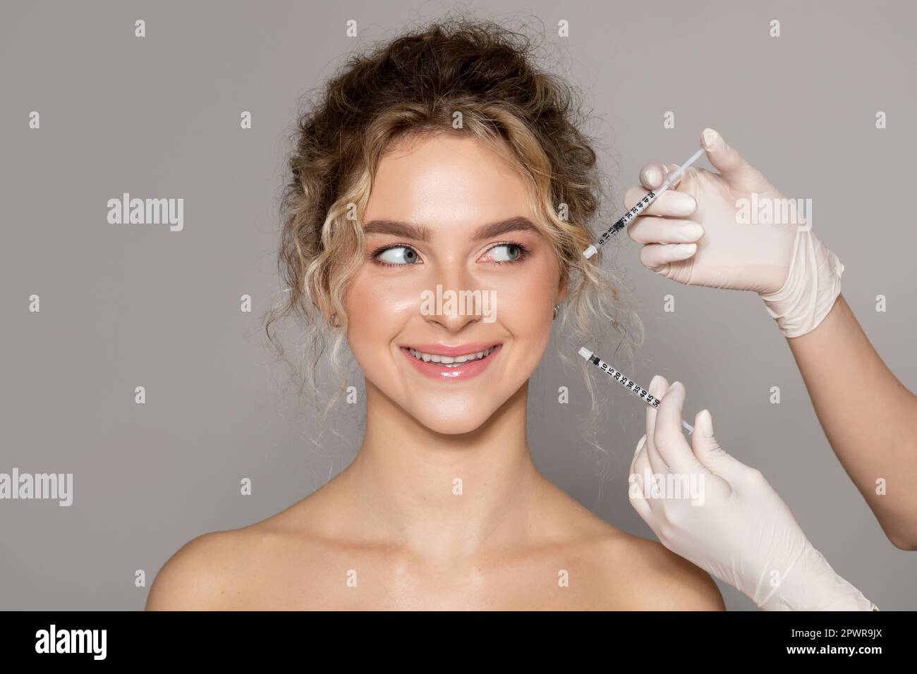 Happy caucasian woman getting facial injection in cheekbones zone ...