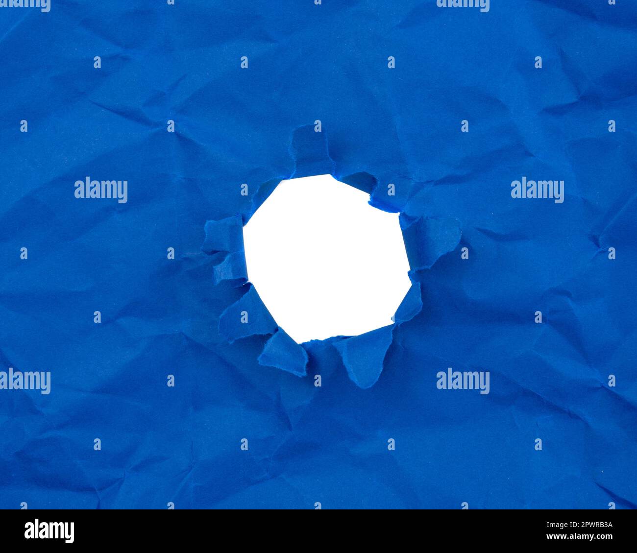 Paper hole with torn sides on a background. Through the paper. A ragged ...