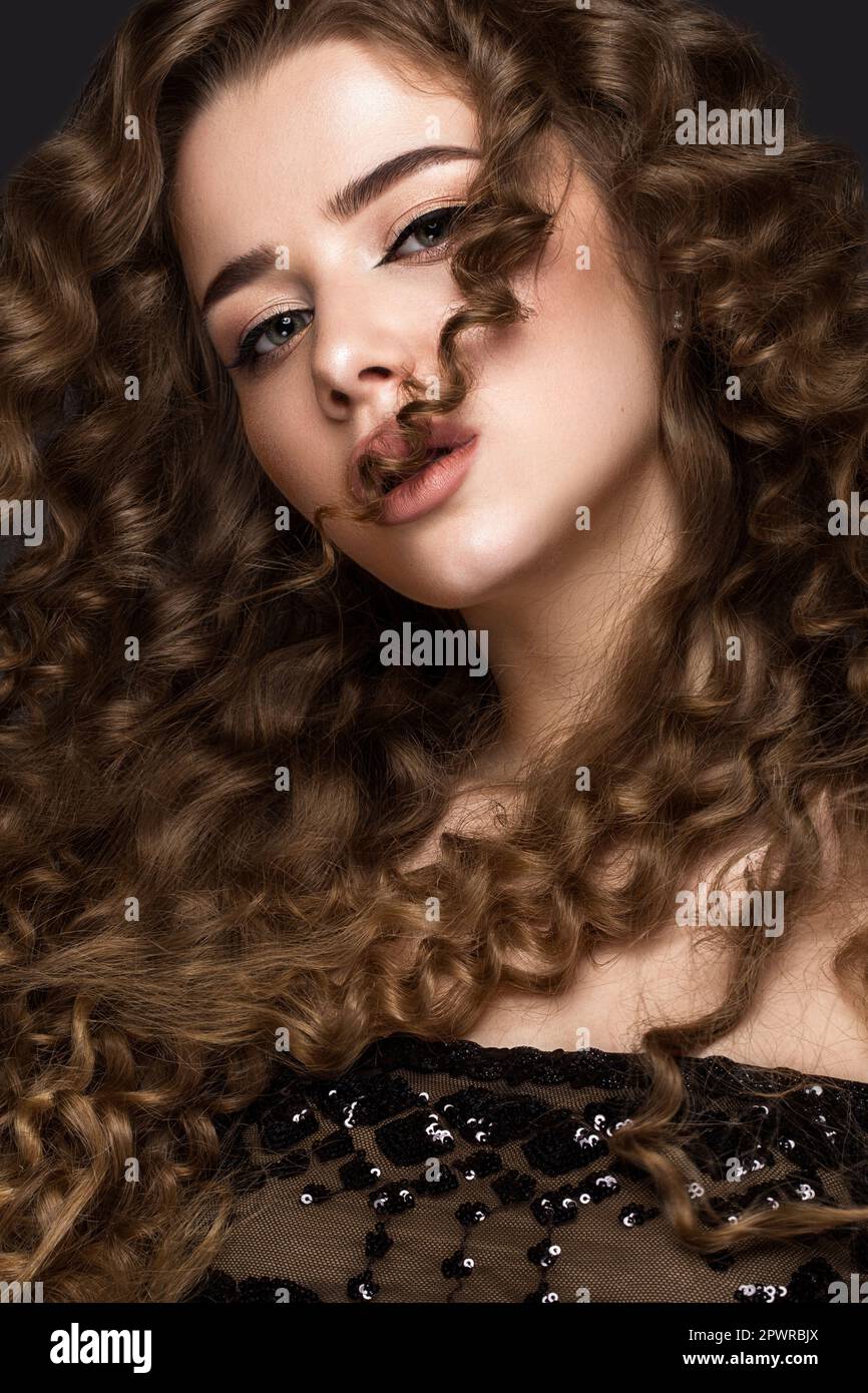 Beautiful brunette girl in move with a perfectly curly hair, and ...