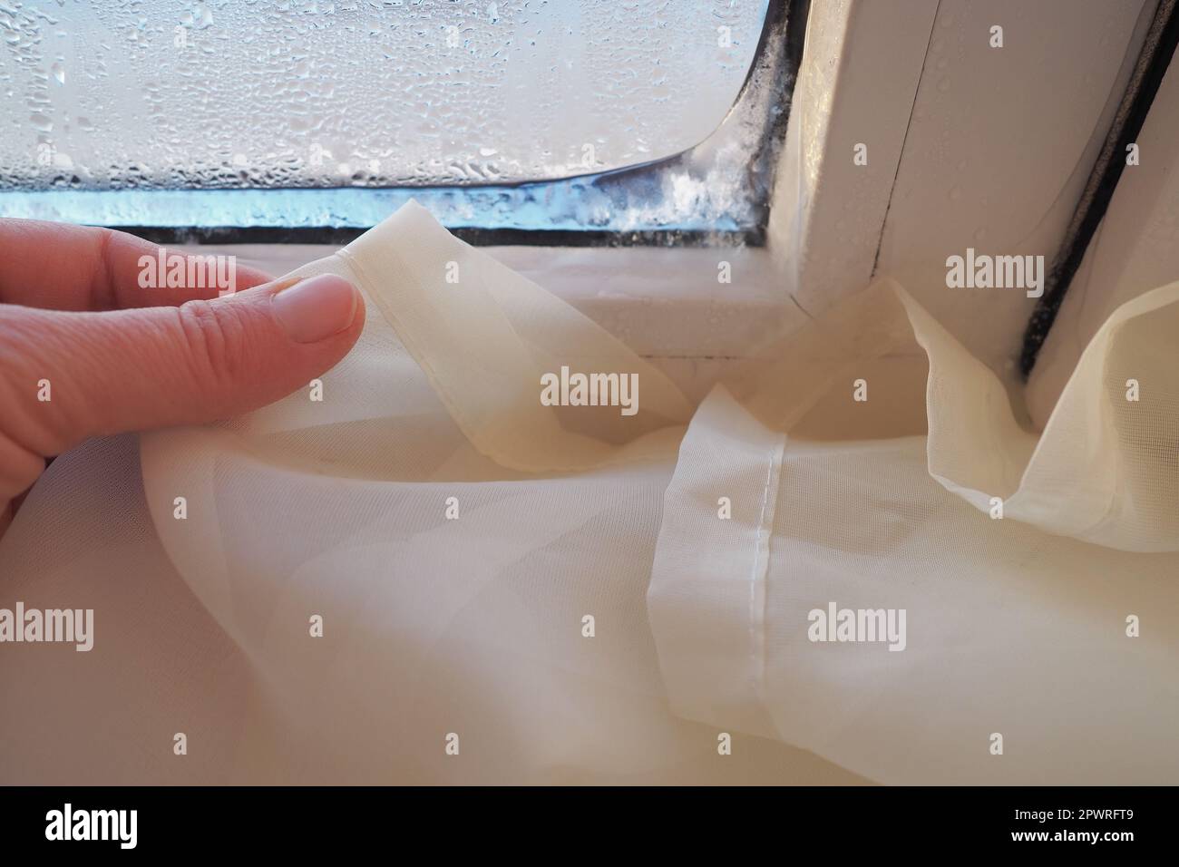 Curtain - white tulle froze to pvc window frame. Melting ice on the ...