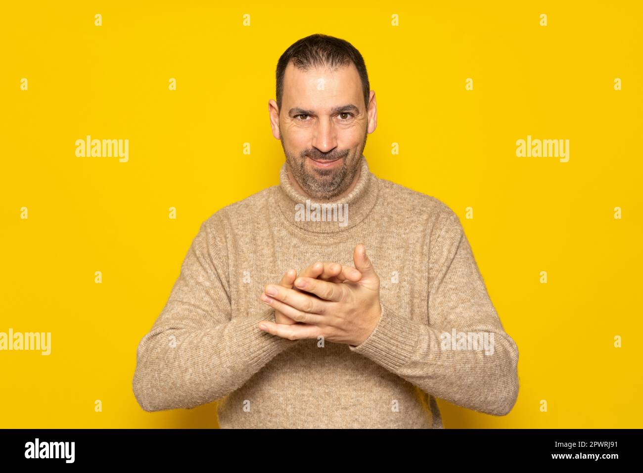 Cunning hispanic man rubbing his hands on isolated yellow background ...