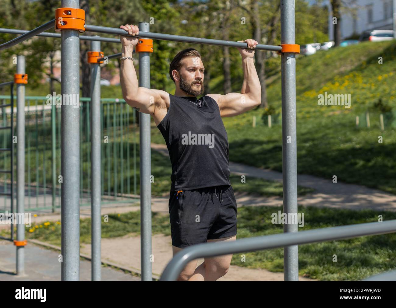 Athletic lebanese man in sportswear doing pull-ups exercises on ...