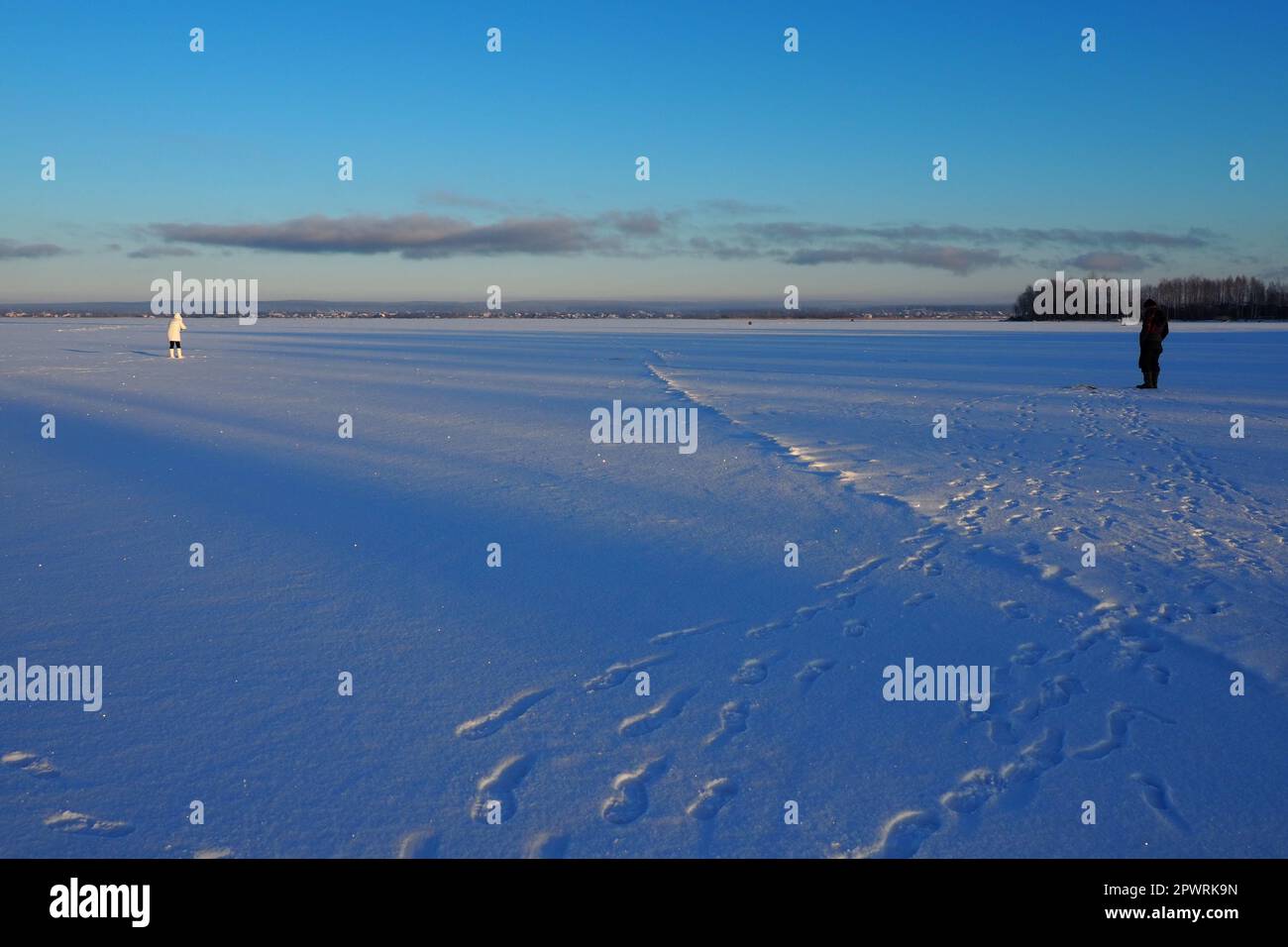 Fisherman and fisherwoman on winter fishing. A man sits near a hole in ...