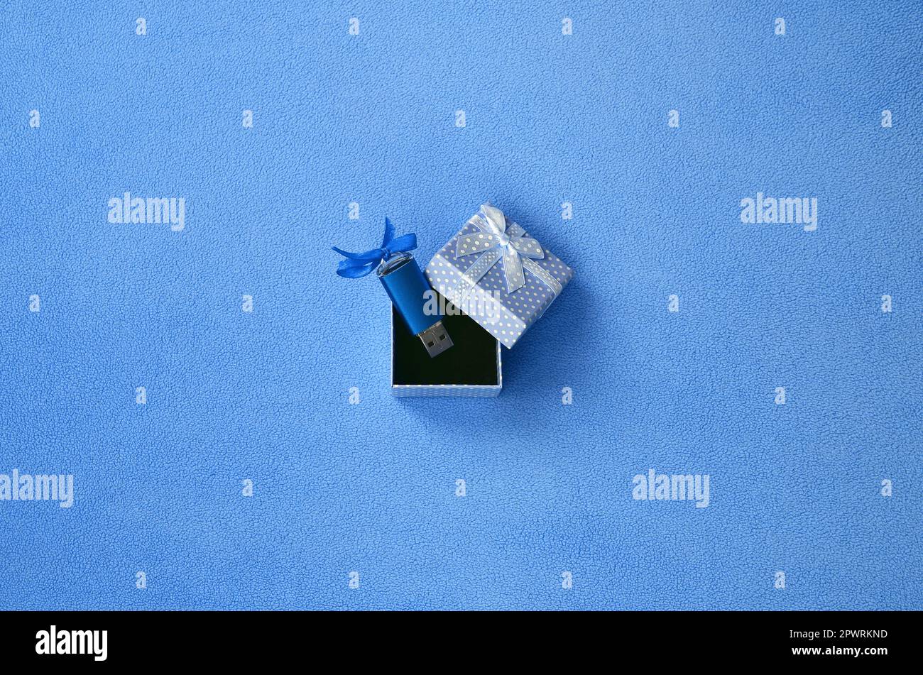 Brilliant blue usb flash memory card with a blue bow lies in a small ...
