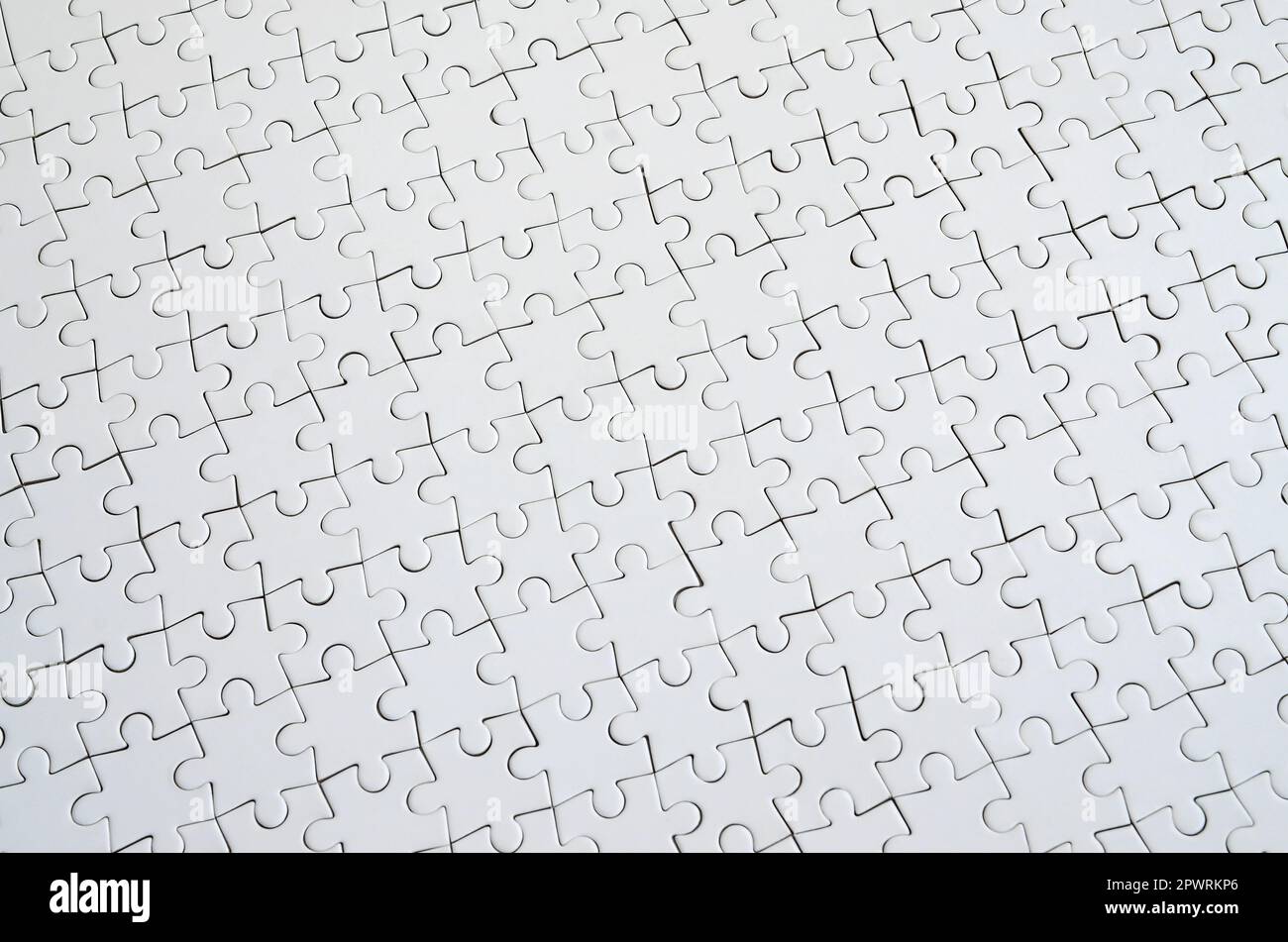 Close up texture of a white jigsaw puzzle in assembled condition. Top ...