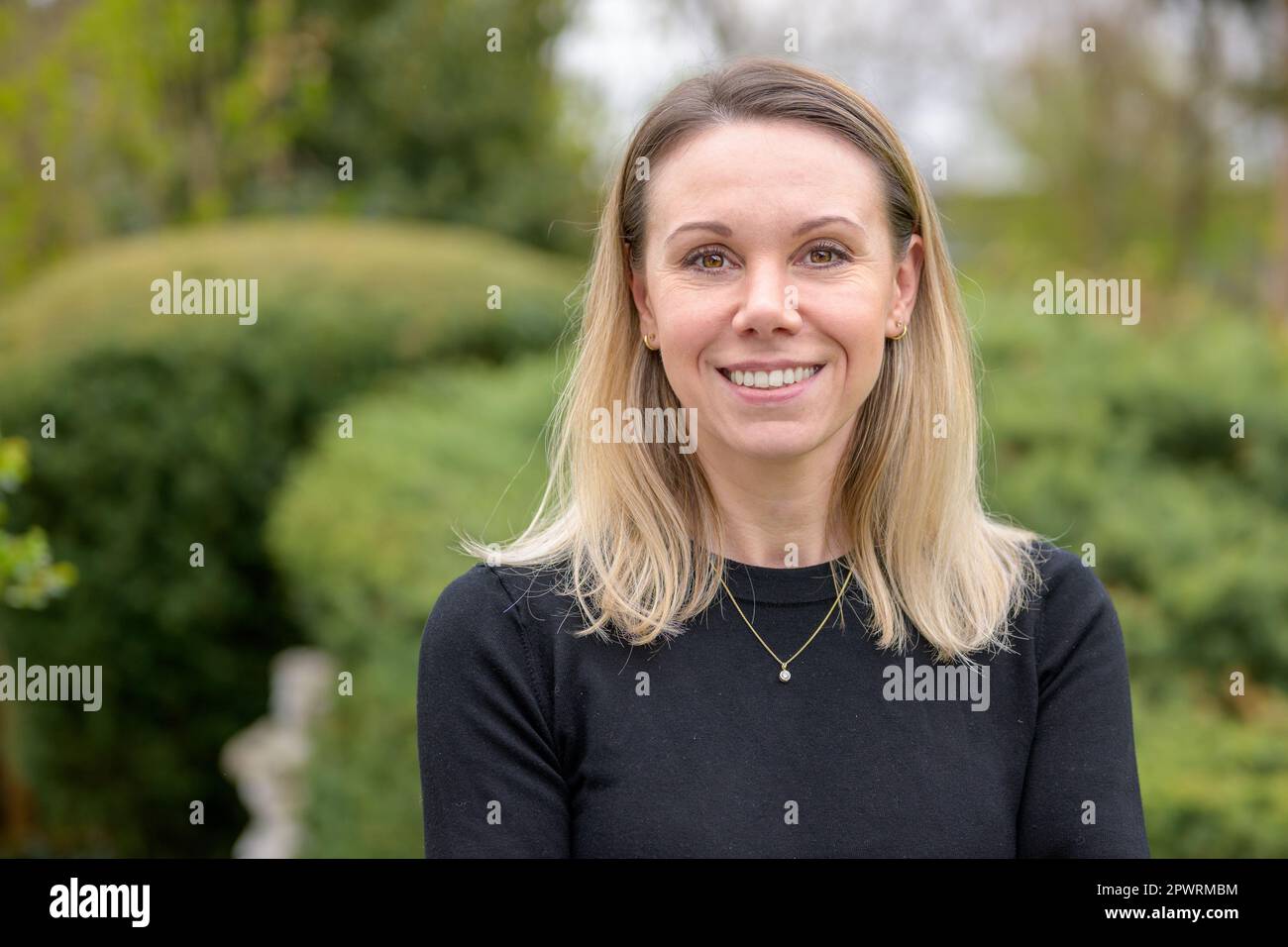 Beautiful blonde woman in her 40s wearing a black shirt and necklace ...