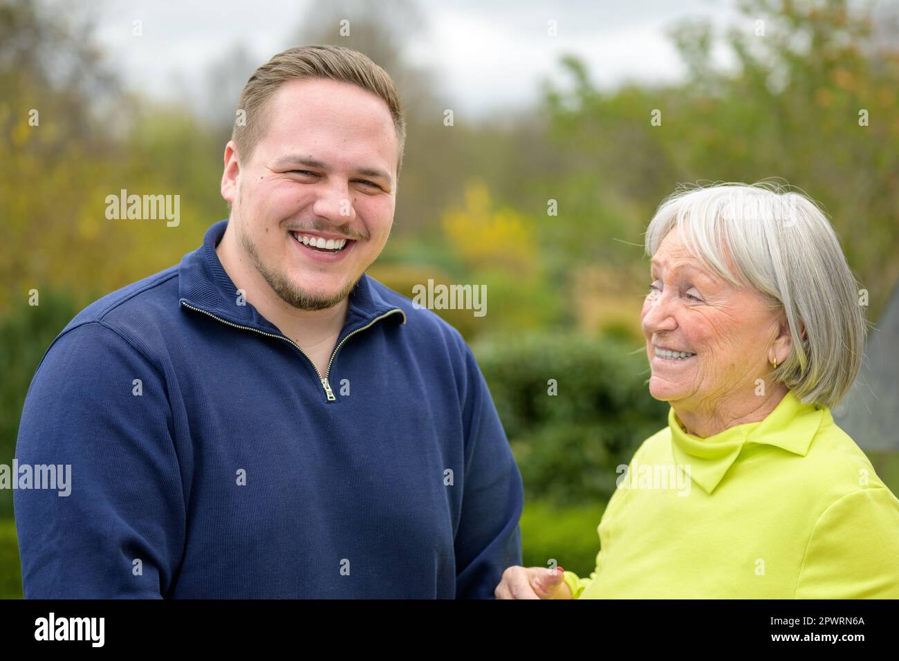 Two generation family, grandmother and grandson standing next to each ...