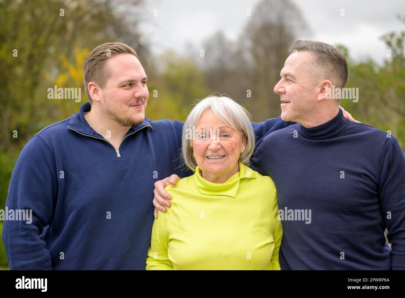 Three generation family, grandmother, son and grandson hold each other ...