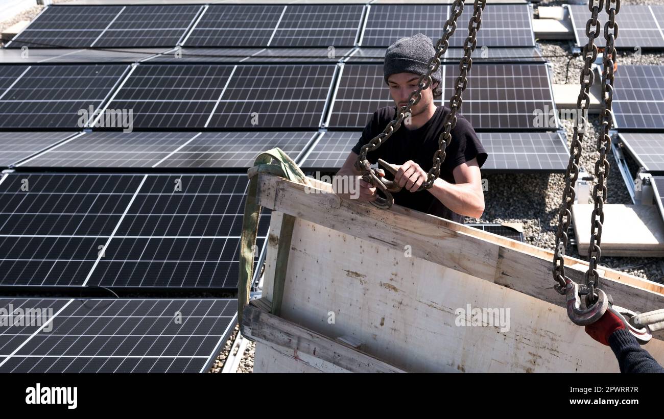 Male team engineers installing stand-alone solar photovoltaic panel ...