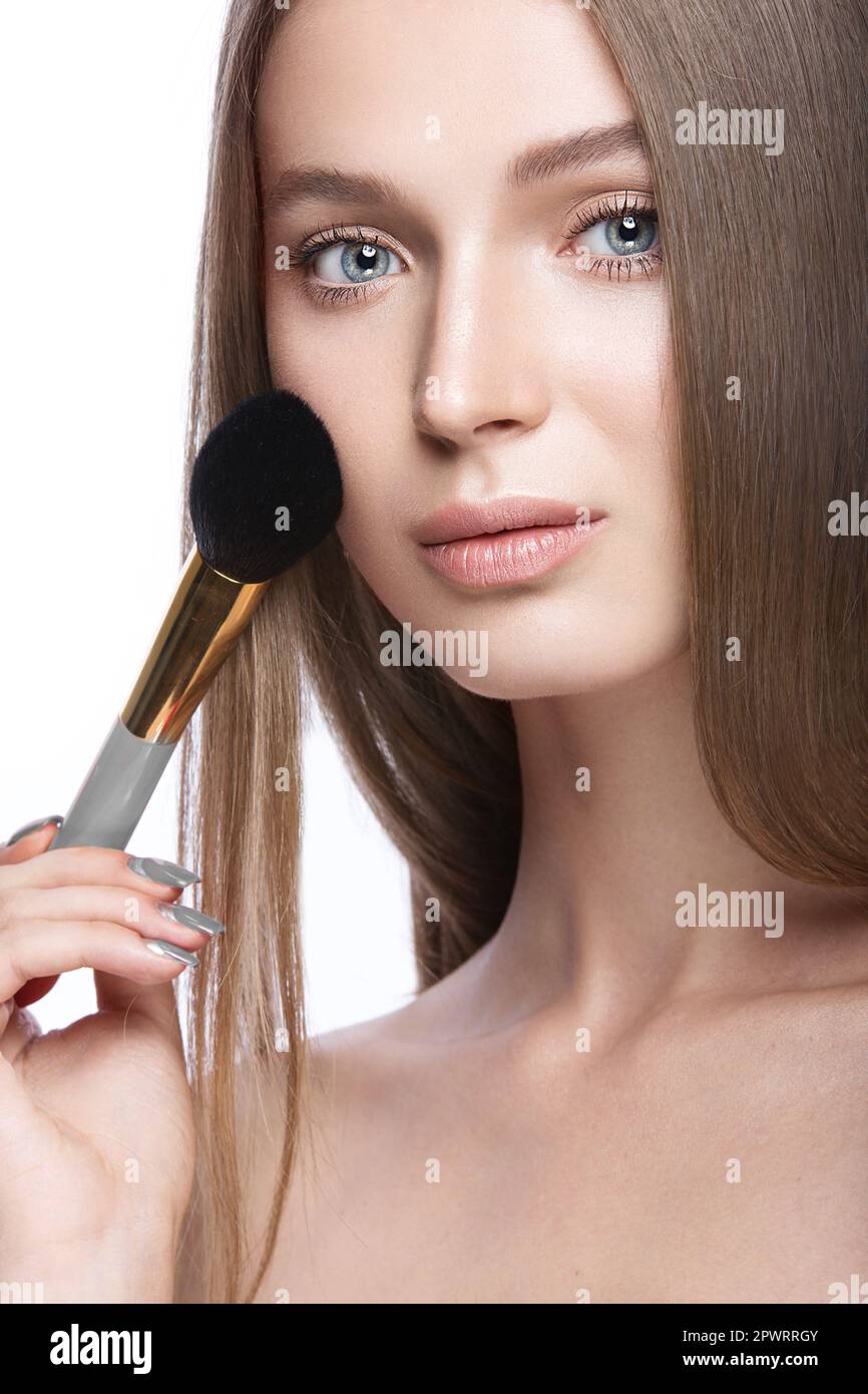 Beautiful young girl with a light natural make-up and beauty tools in ...