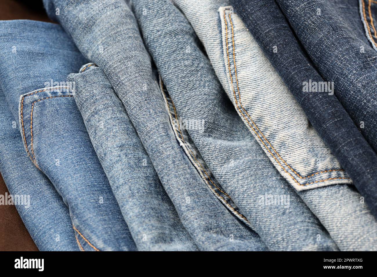 Many jeans in stack in wardrobe room. Row of pants denim jeans in ...