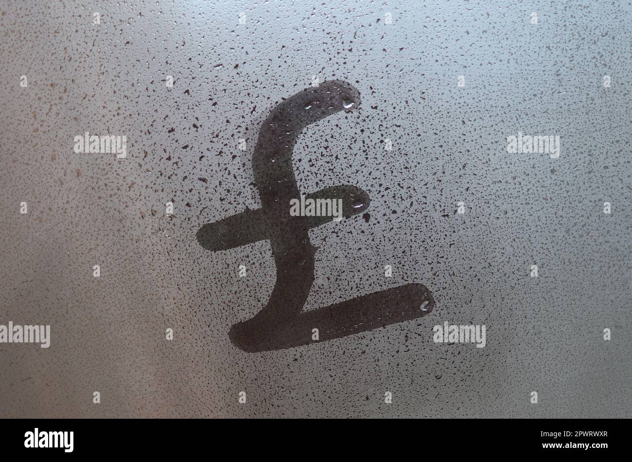 Symbol of English pounds is written with a finger on the surface of the ...